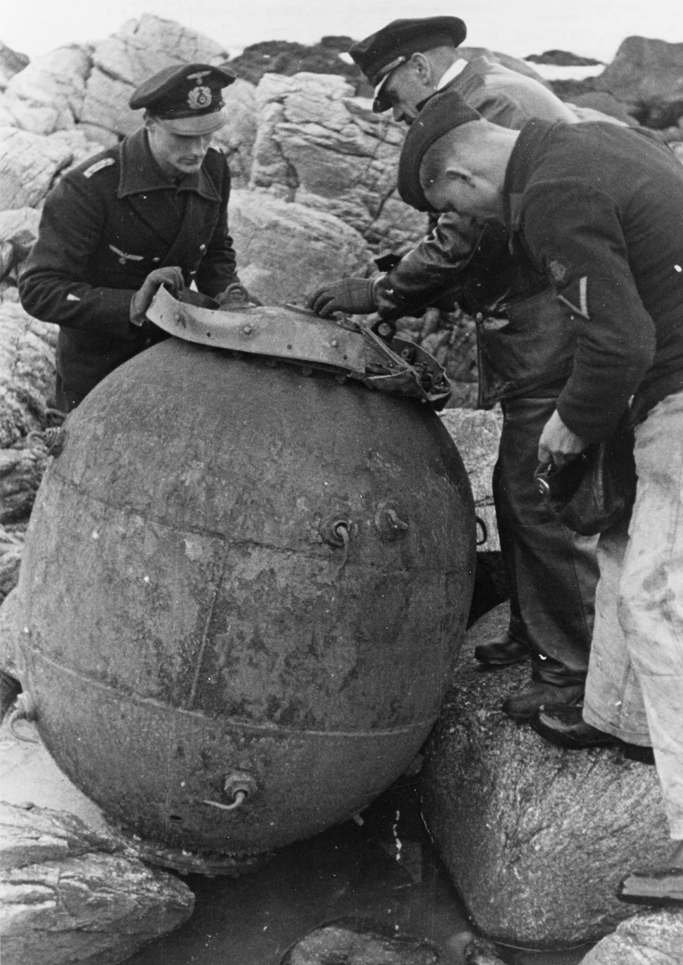 Asisbiz German naval personnel examining a cast up mine on the ...